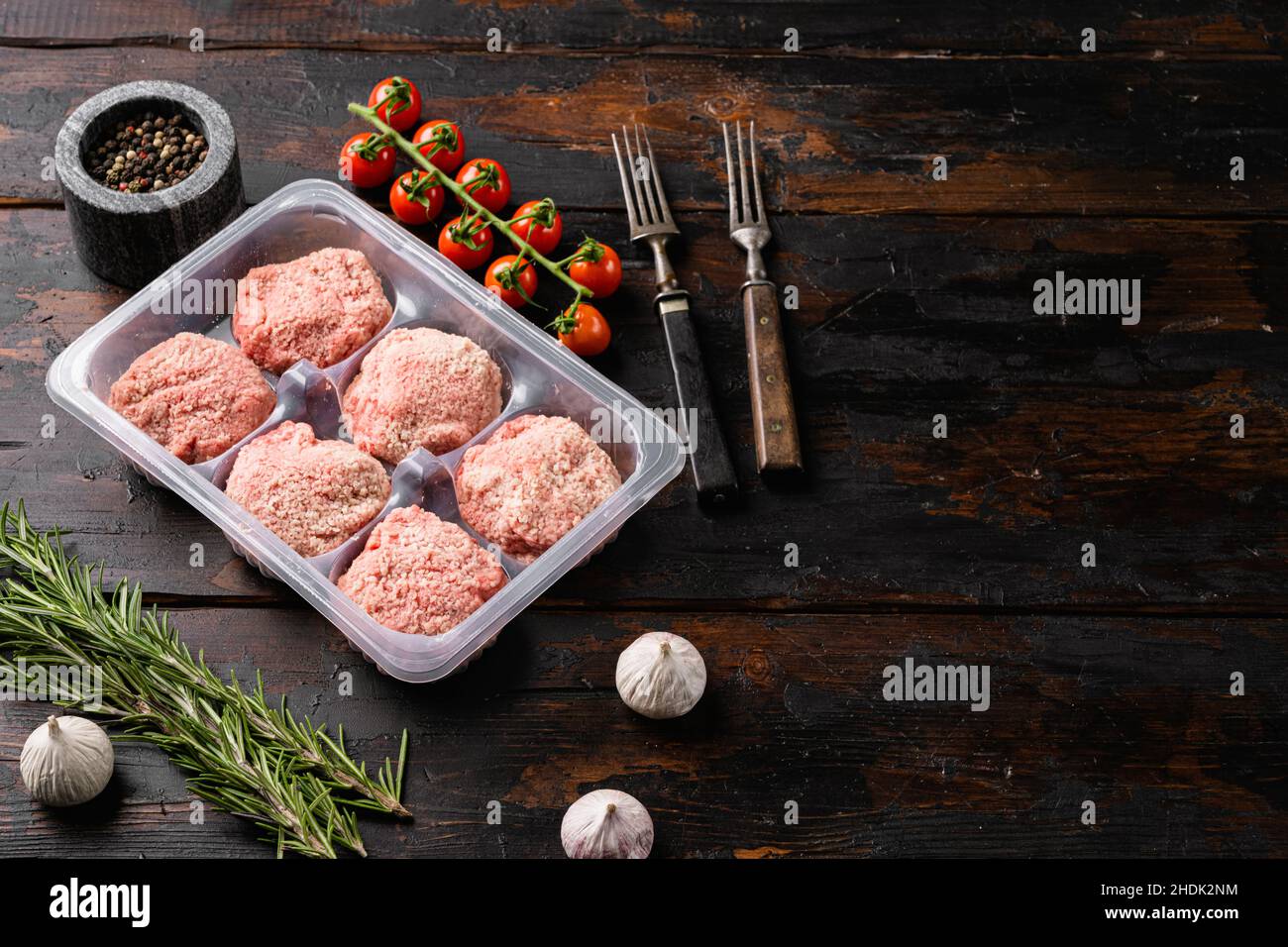 Raw turkey meatballs in plastic disposable tray set, on old dark wooden ...
