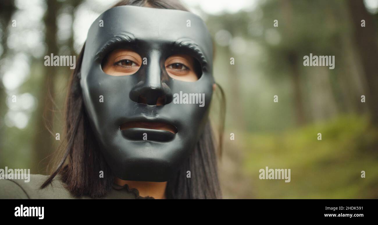 Closeup shot of a young female posing in a scary black mask Stock Photo ...