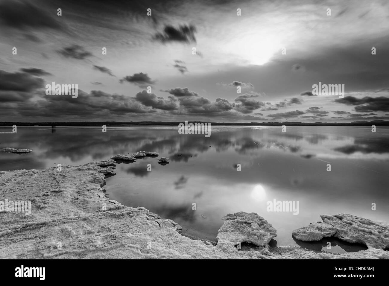 Scenic grayscale view of a sunset reflection in the water in a long ...