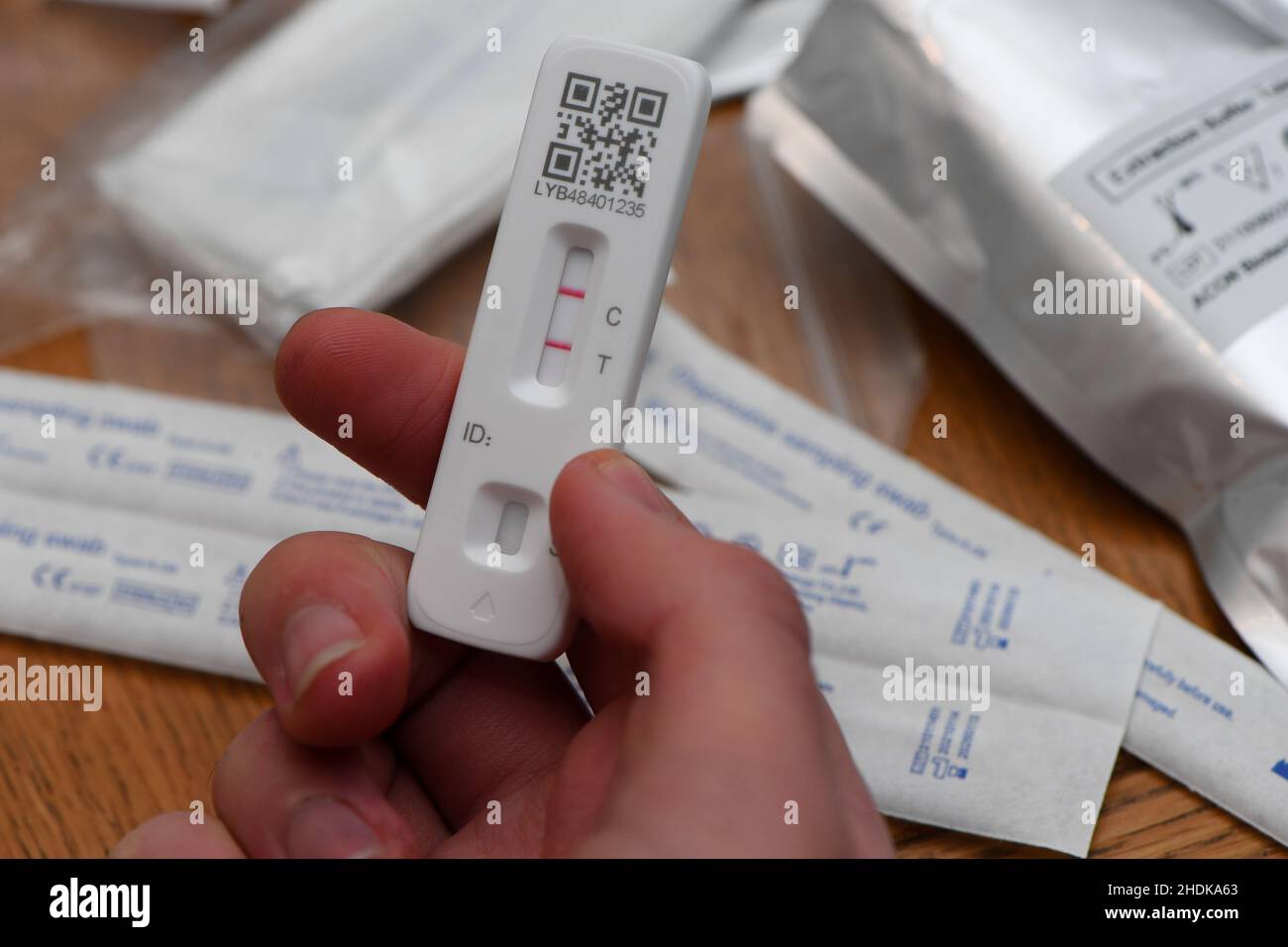 A positive Covid-19 lateral flow test held in the hand showing the two ...
