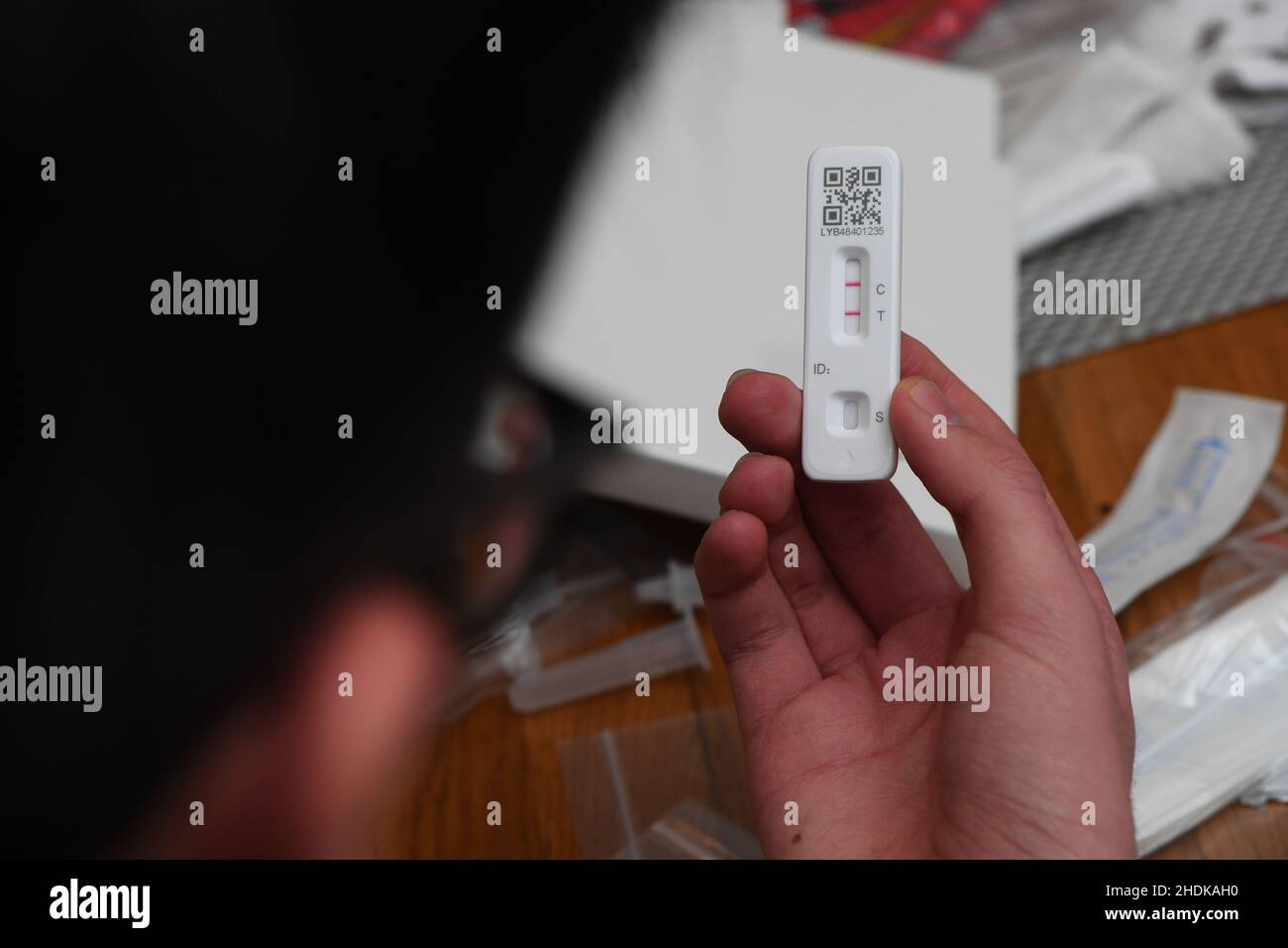A positive Covid-19 lateral flow test held in the hand showing the two ...