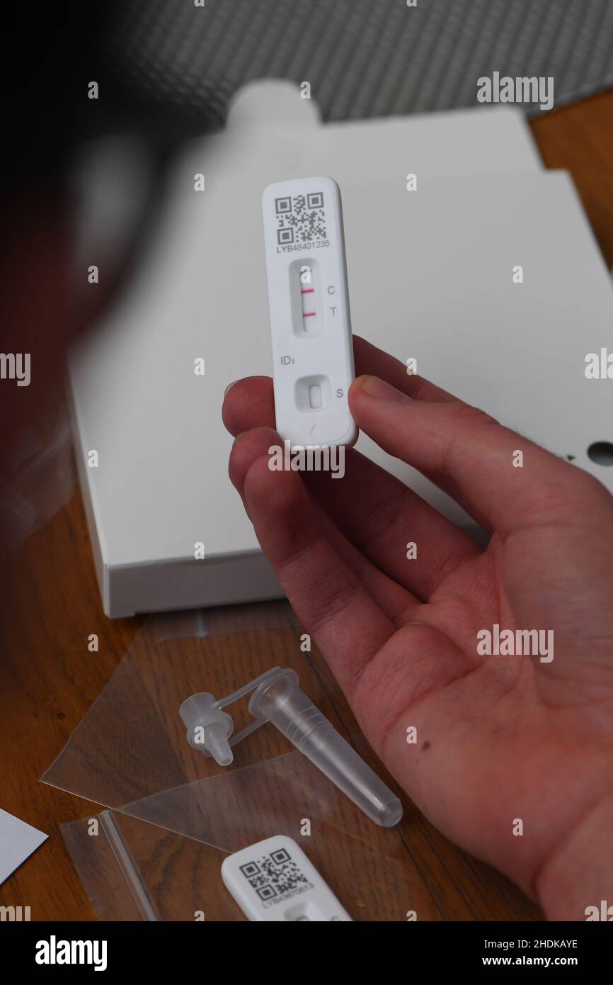A positive Covid-19 lateral flow test held in the hand showing the two ...