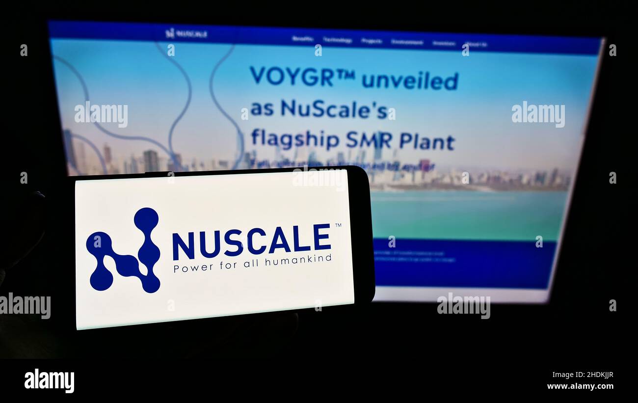Person holding smartphone with logo of US nuclear power company NuScale ...