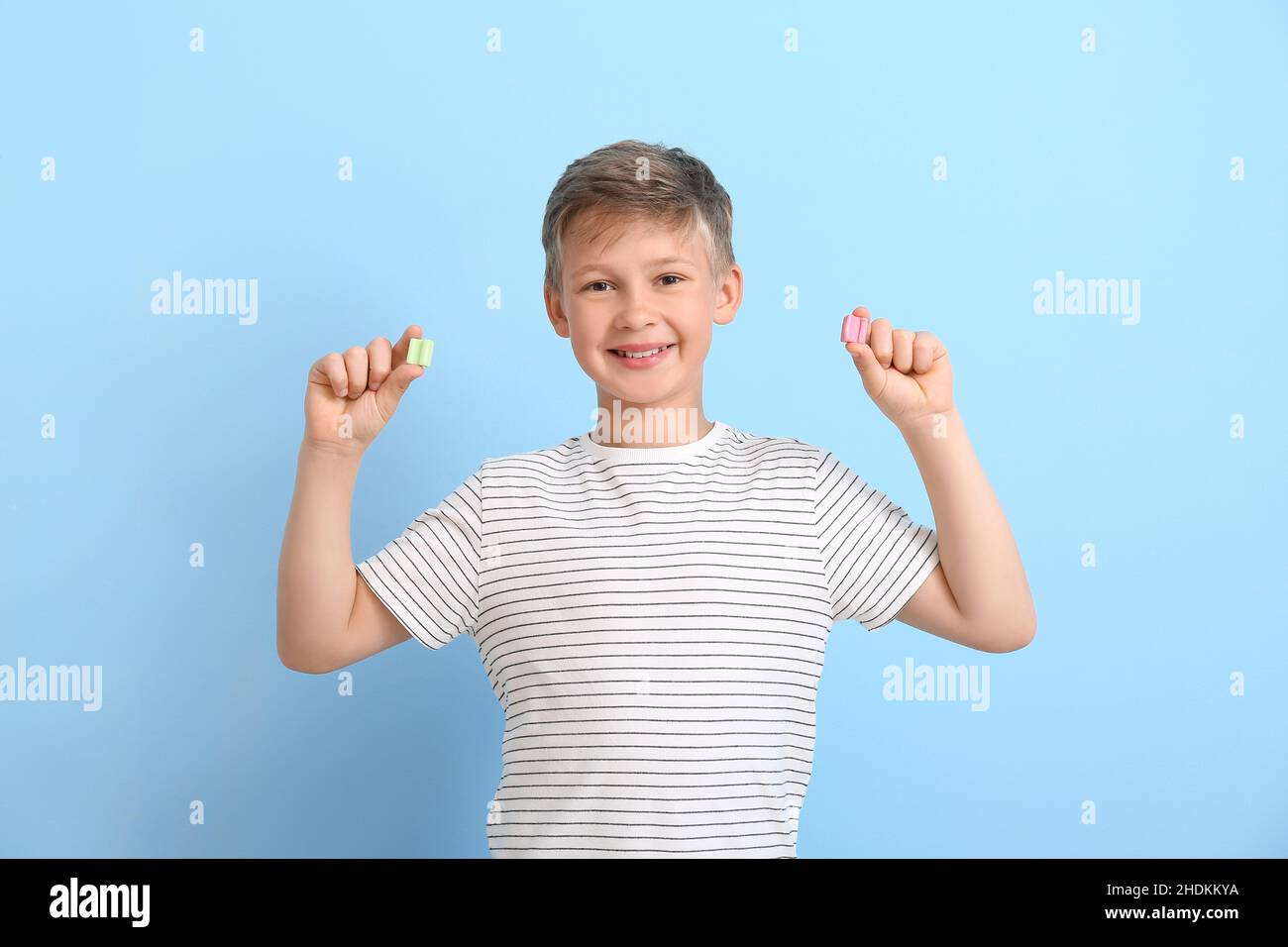 Little boy with chewing gums on blue background Stock Photo - Alamy