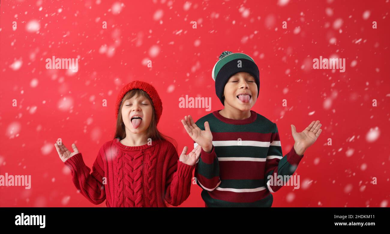 Cute little children in winter sweaters catching falling snow with ...