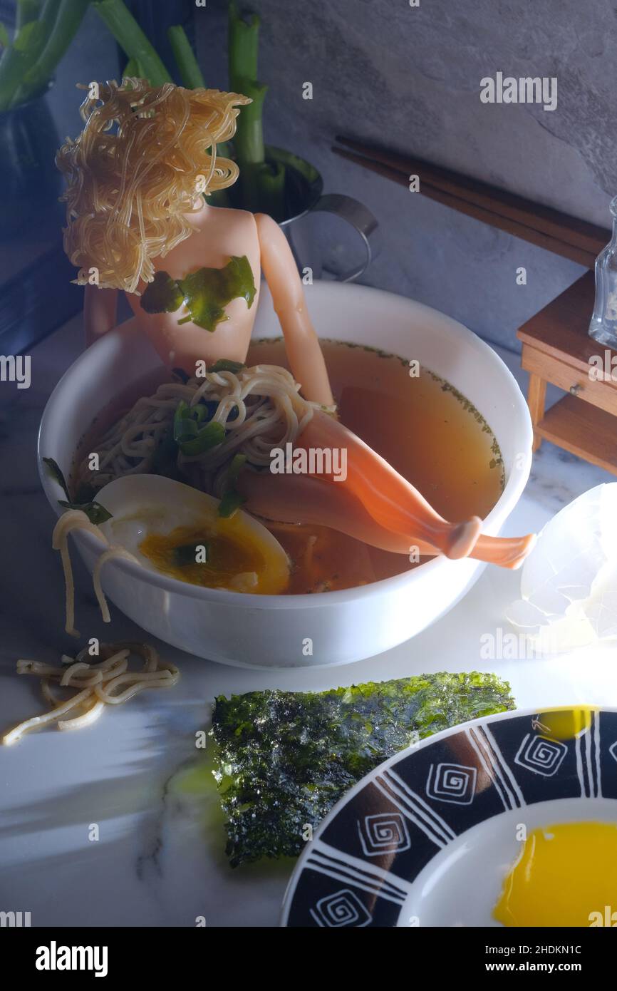 Relaxed doll bathes in Japanese ramen noodles concept Stock Photo - Alamy