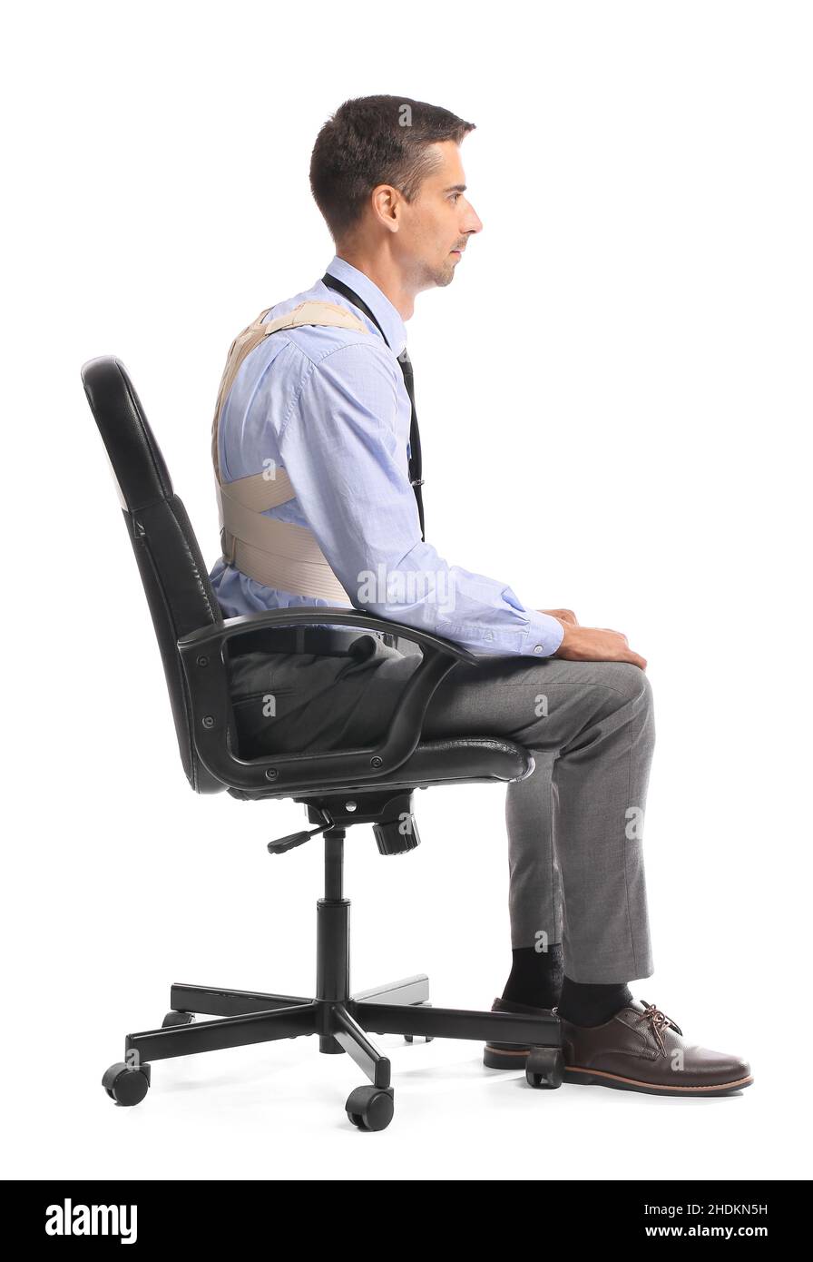 Businessman in back brace sitting on chair against white background ...