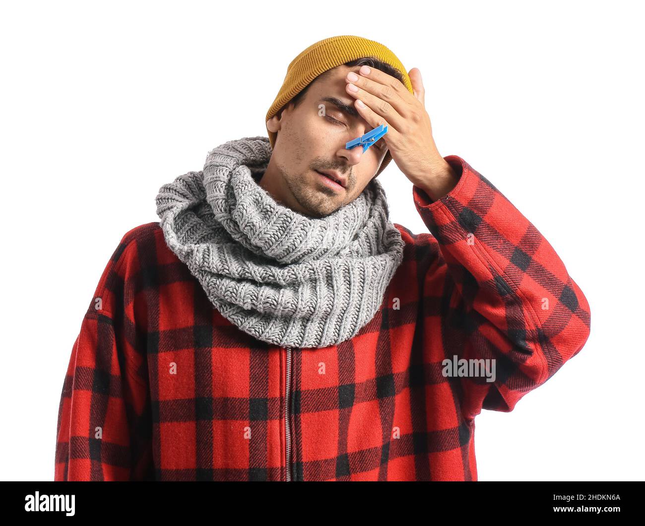 Ill young man with clothespin on his nose against white background ...