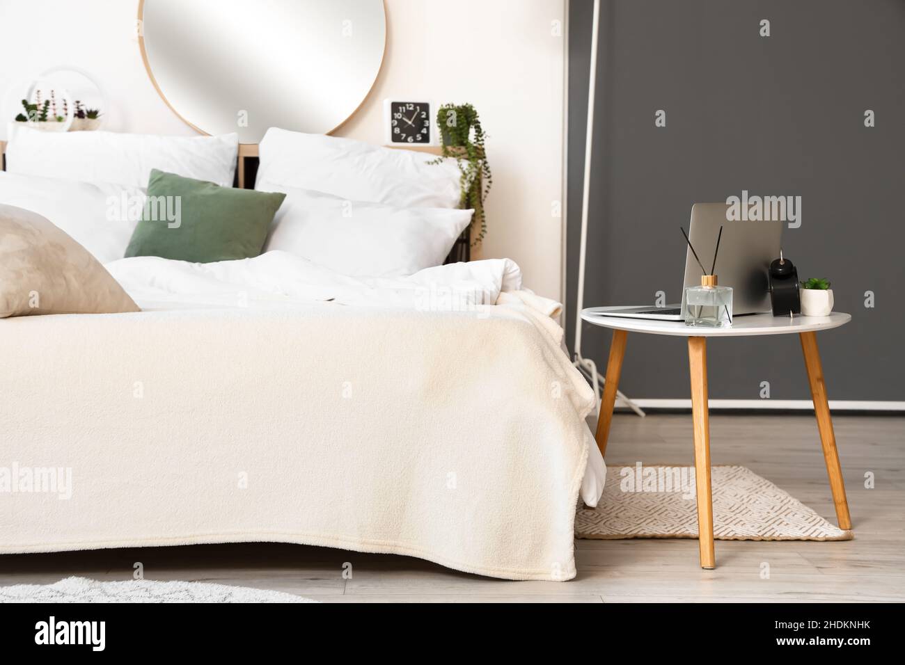 Stylish light bedroom with wooden bedside table near window Stock Photo ...