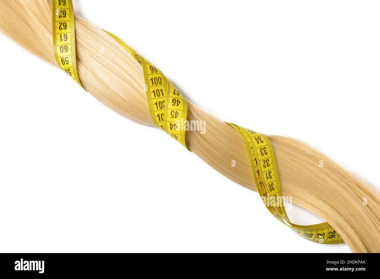 Blonde hair strand for donation with measuring tape on white background ...