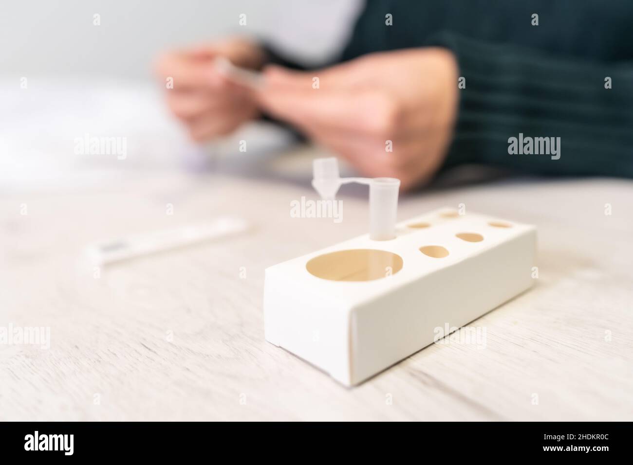 Reactive liquid in the had. A young woman doing the rapid antigen test ...