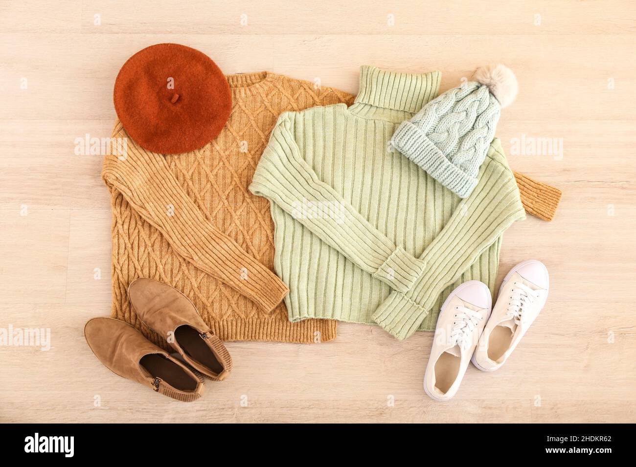 Stylish female outfits on light wooden background Stock Photo - Alamy