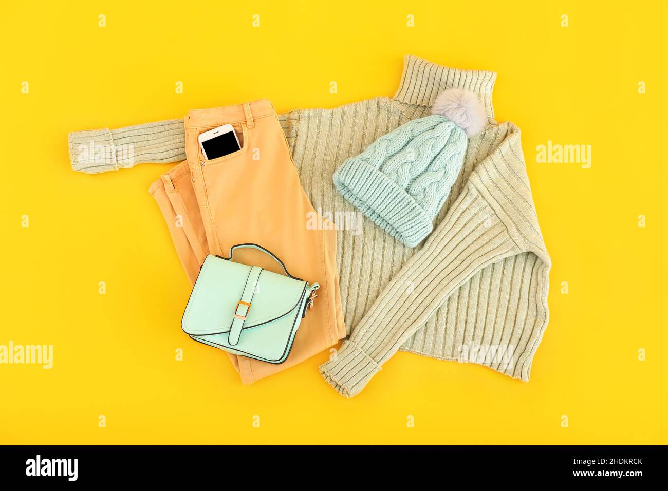 Stylish female clothes, mobile phone and accessories on yellow ...
