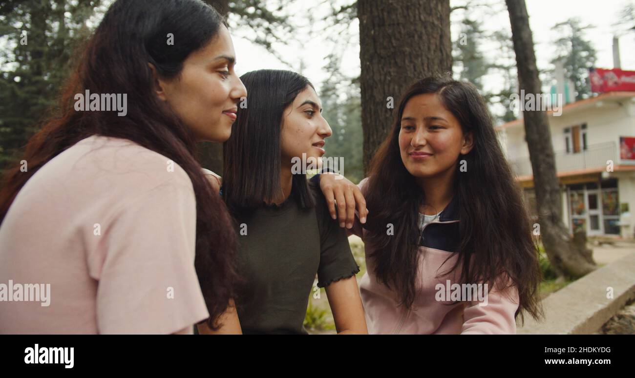 Group of young Indian female friends talking and laughing in a park ...