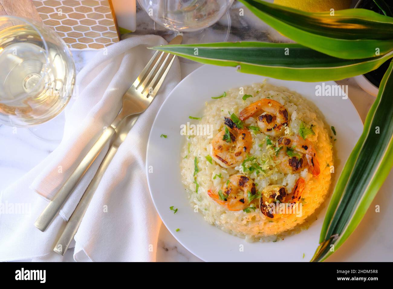 Fancy Italian shrimp risotto dinner served with a glass of fine pinot ...