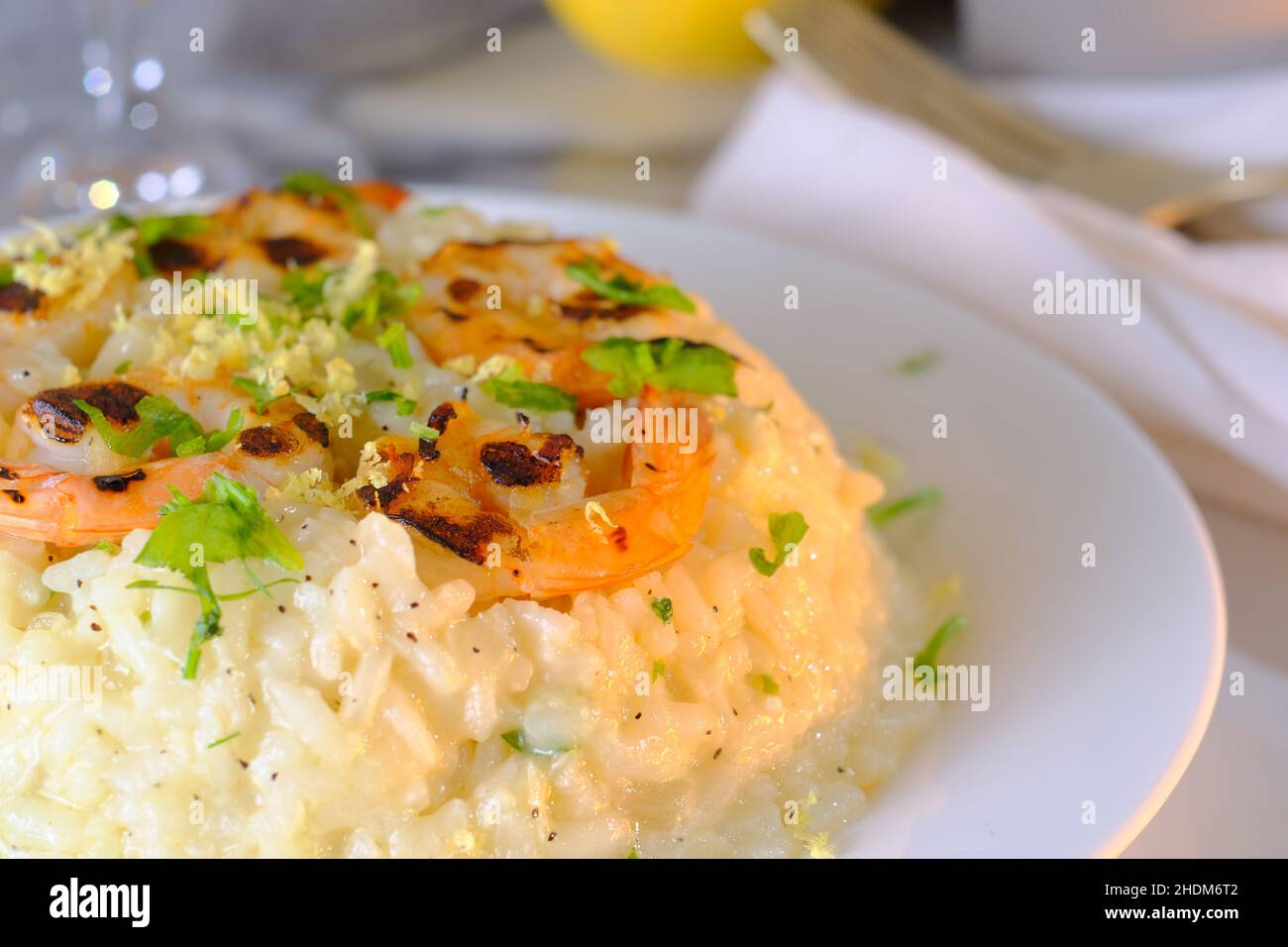 Fancy Italian shrimp risotto dinner served with a glass of fine pinot ...