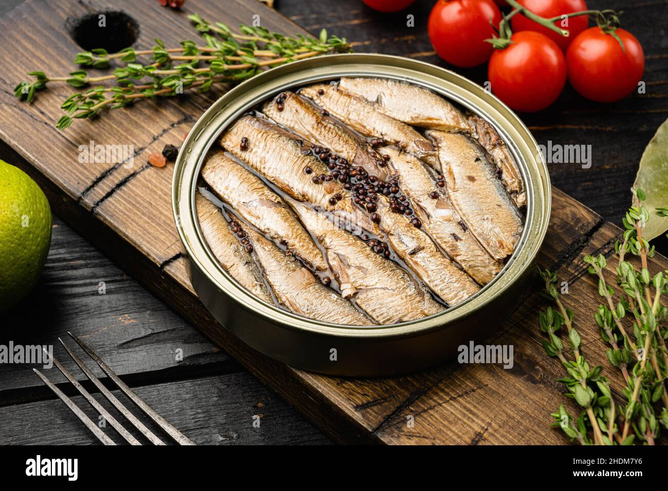 Canned fish in tin can with sardine set, on black wooden table ...