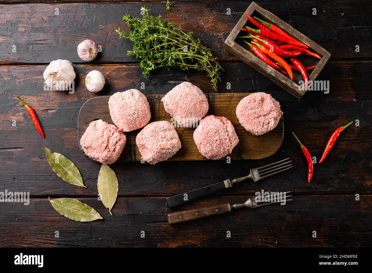 Raw minced meat made into meatballs, on old dark wooden table ...