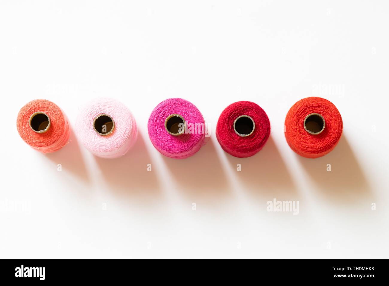 Colorful thread spools on a white background with copy space for text ...