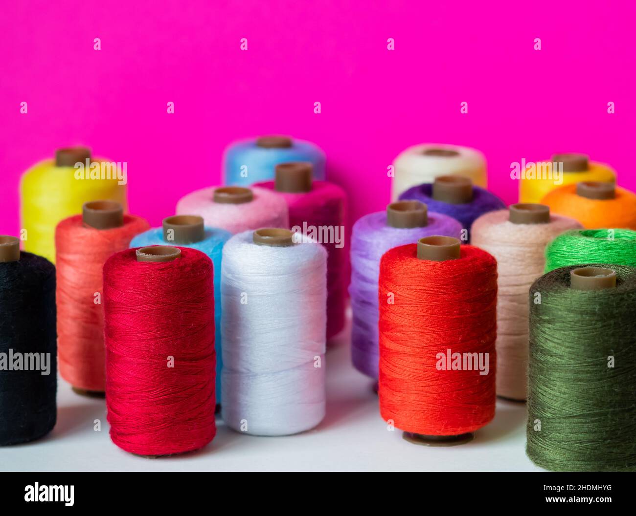 Colorful thread spools on a white background with copy space for text ...