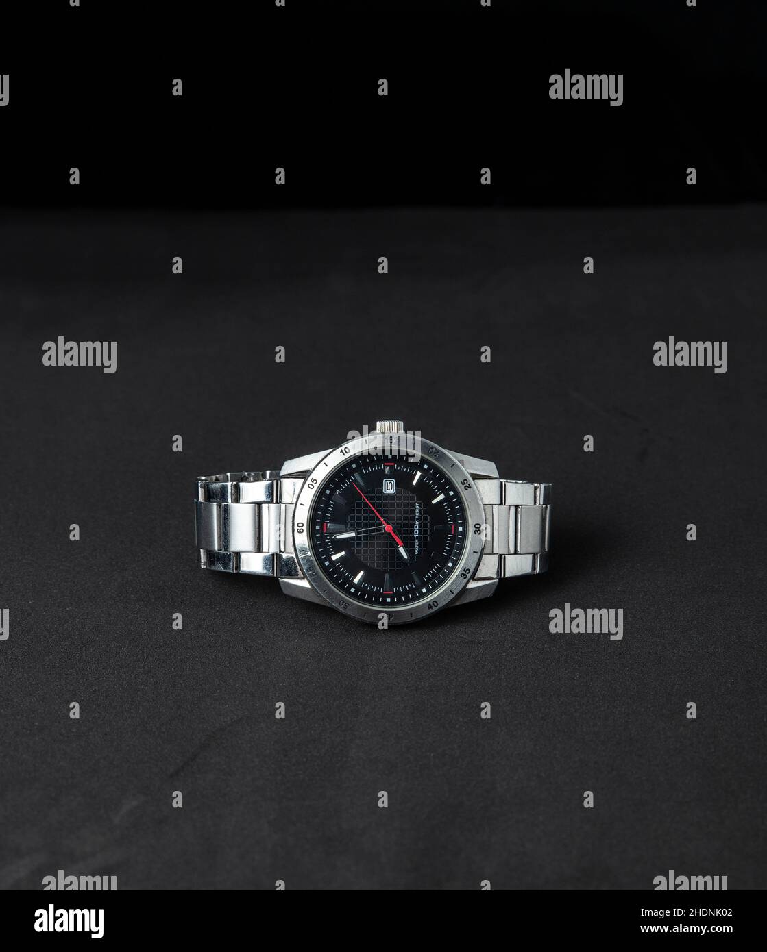 Vertical closeup of a shiny silver watch on a black surface Stock Photo ...