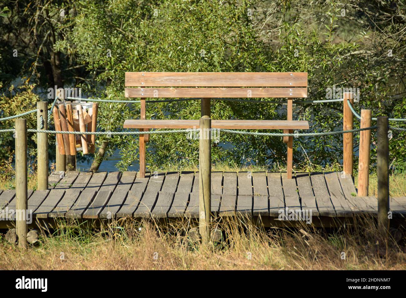 Photo of an outdoor wooden bench surrounded by robe pole fence Stock ...