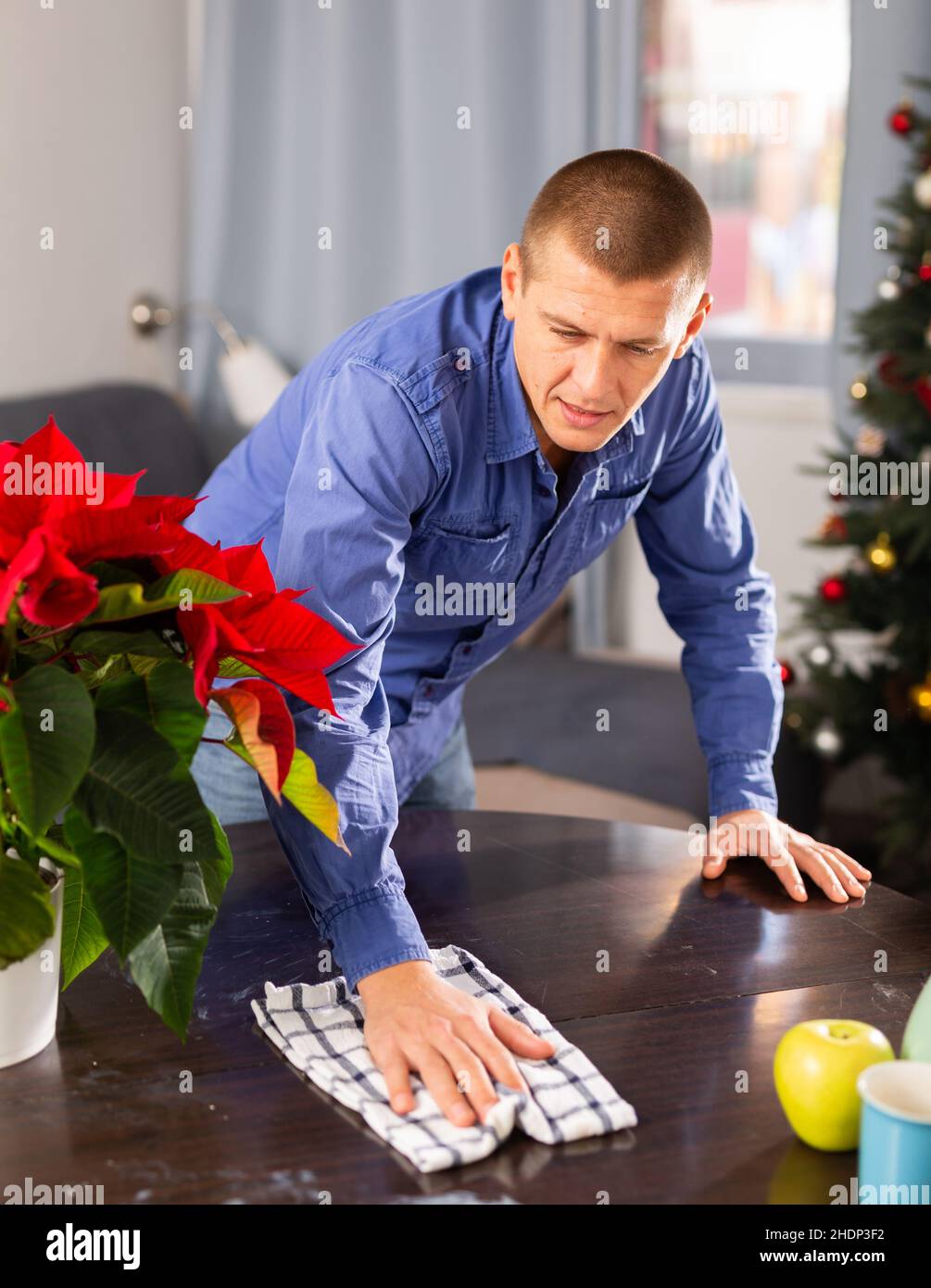 Man cleaning table with rag at home before christmas Stock Photo - Alamy