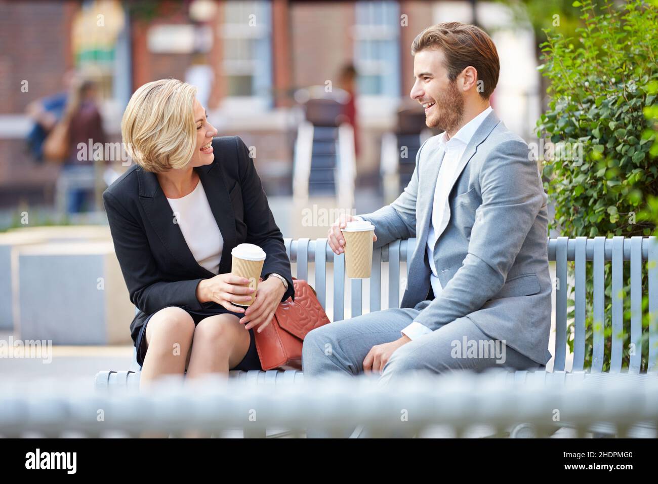 Female colleagues sitting outdoors drinking hi-res stock photography ...