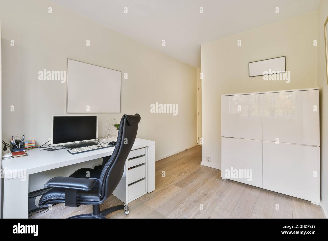 Comfortable work room with white table and paintings on the wall Stock ...
