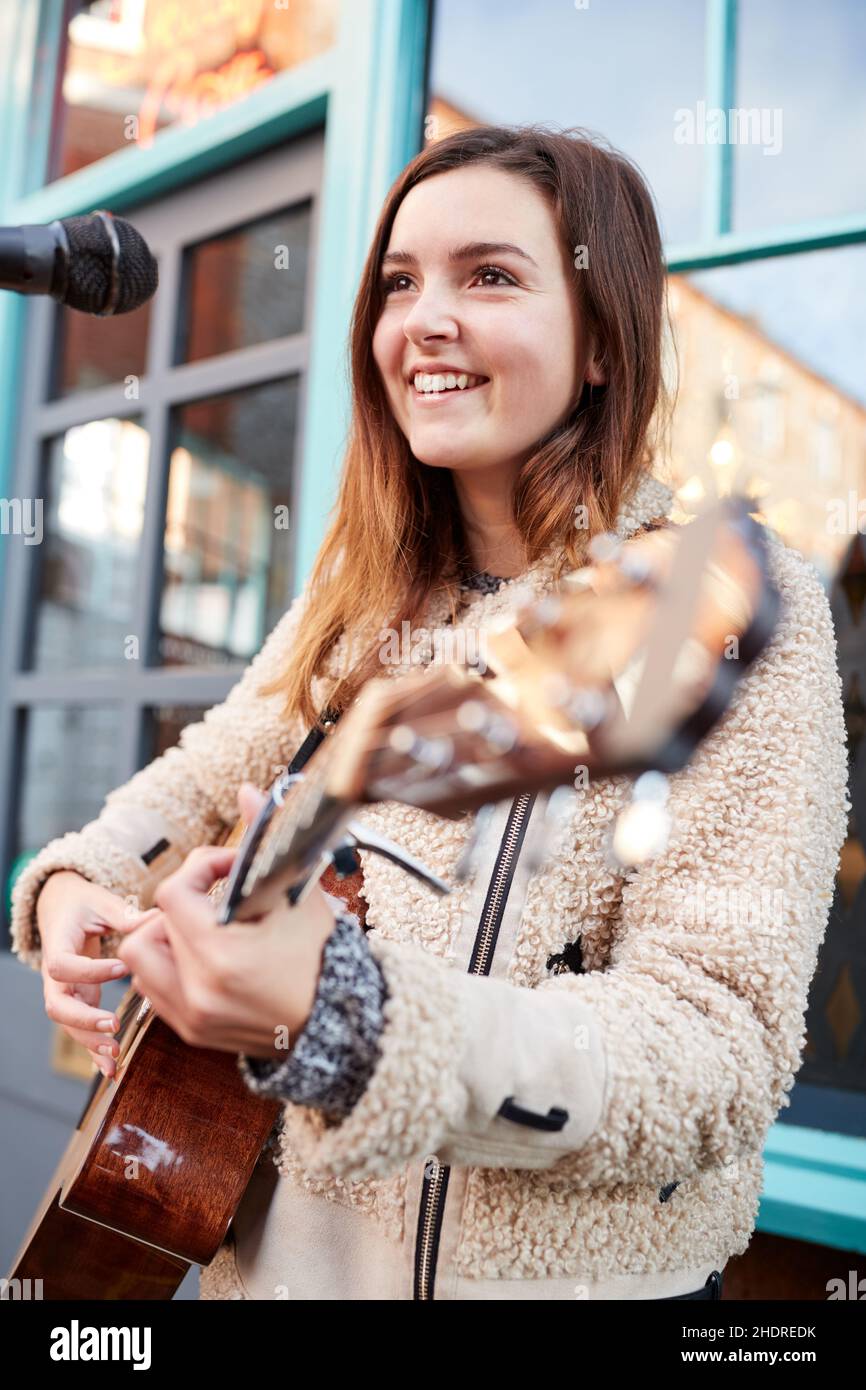 Busker girl playing guitar hi-res stock photography and images - Alamy