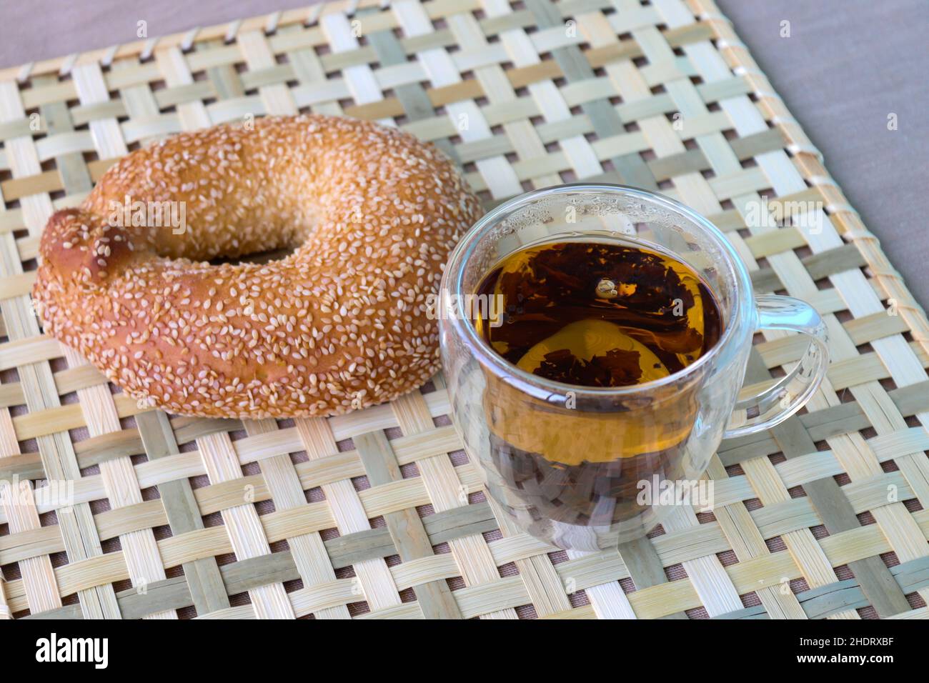 Glass cup of black tea and sesame bagel Stock Photo - Alamy