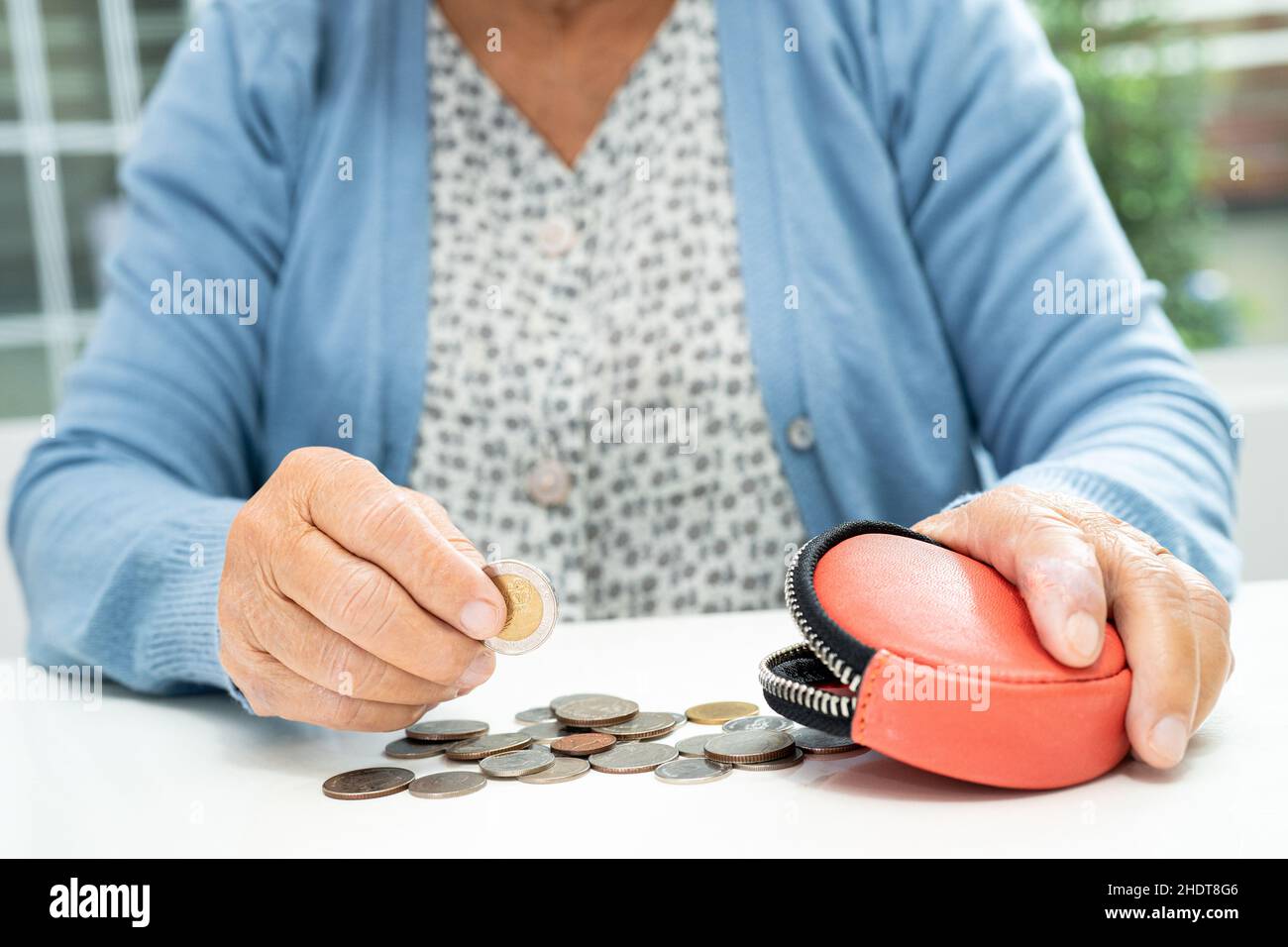 Asian senior or elderly old lady woman holding counting coin money in ...