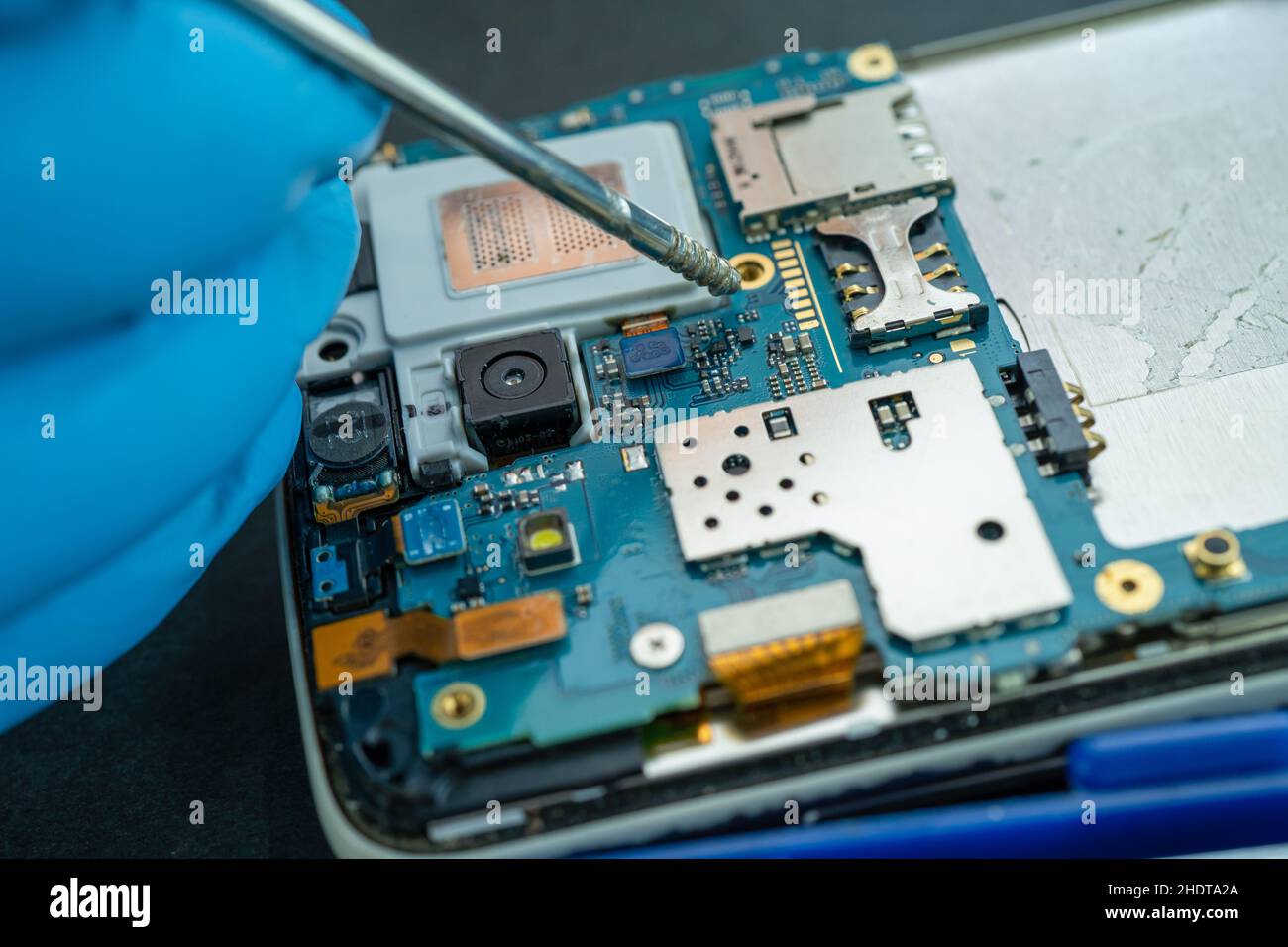 Technician repairing inside of mobile phone by soldering iron ...