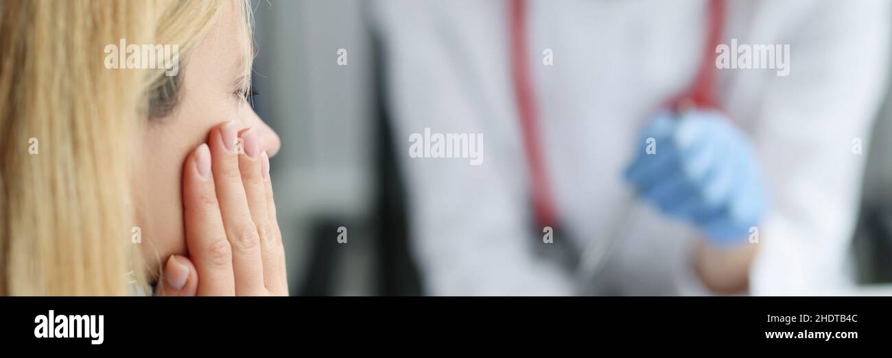 Woman at doctor appointment with toothache closeup Stock Photo - Alamy