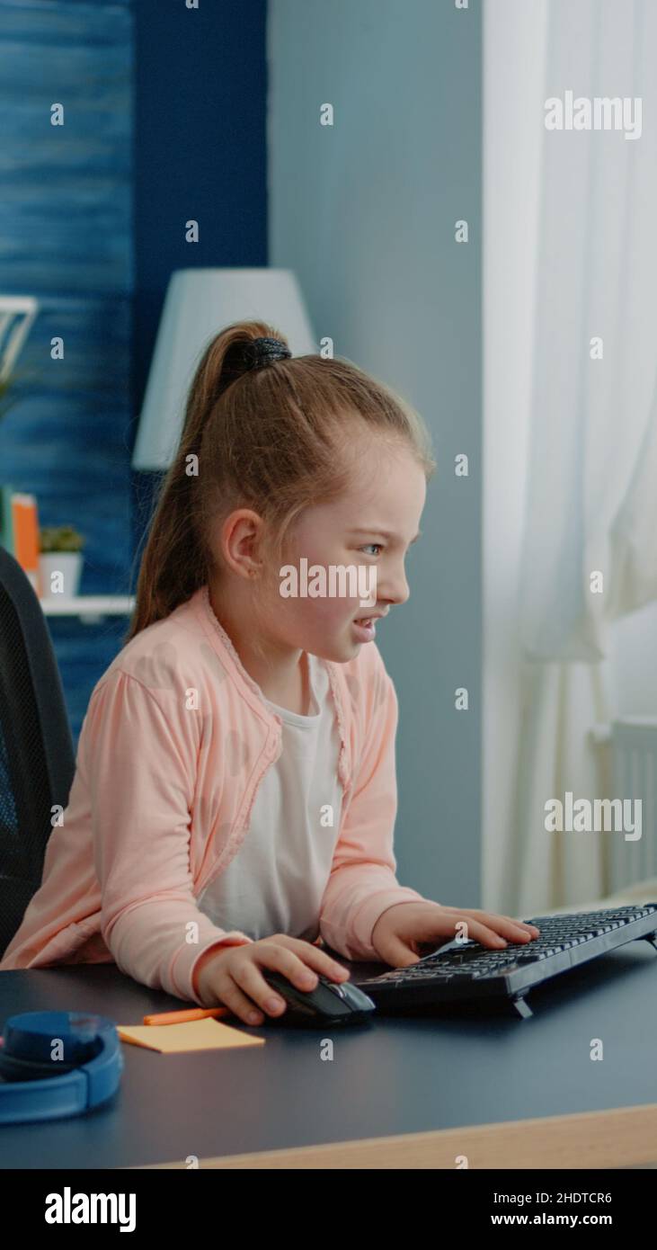 Frustrated child using computer and keyboard for homework at home ...