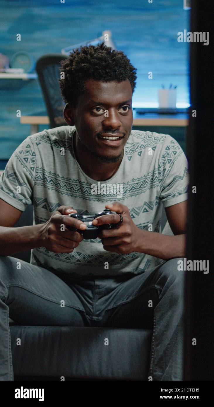 Person playing virtual video games and holding joystick on television ...