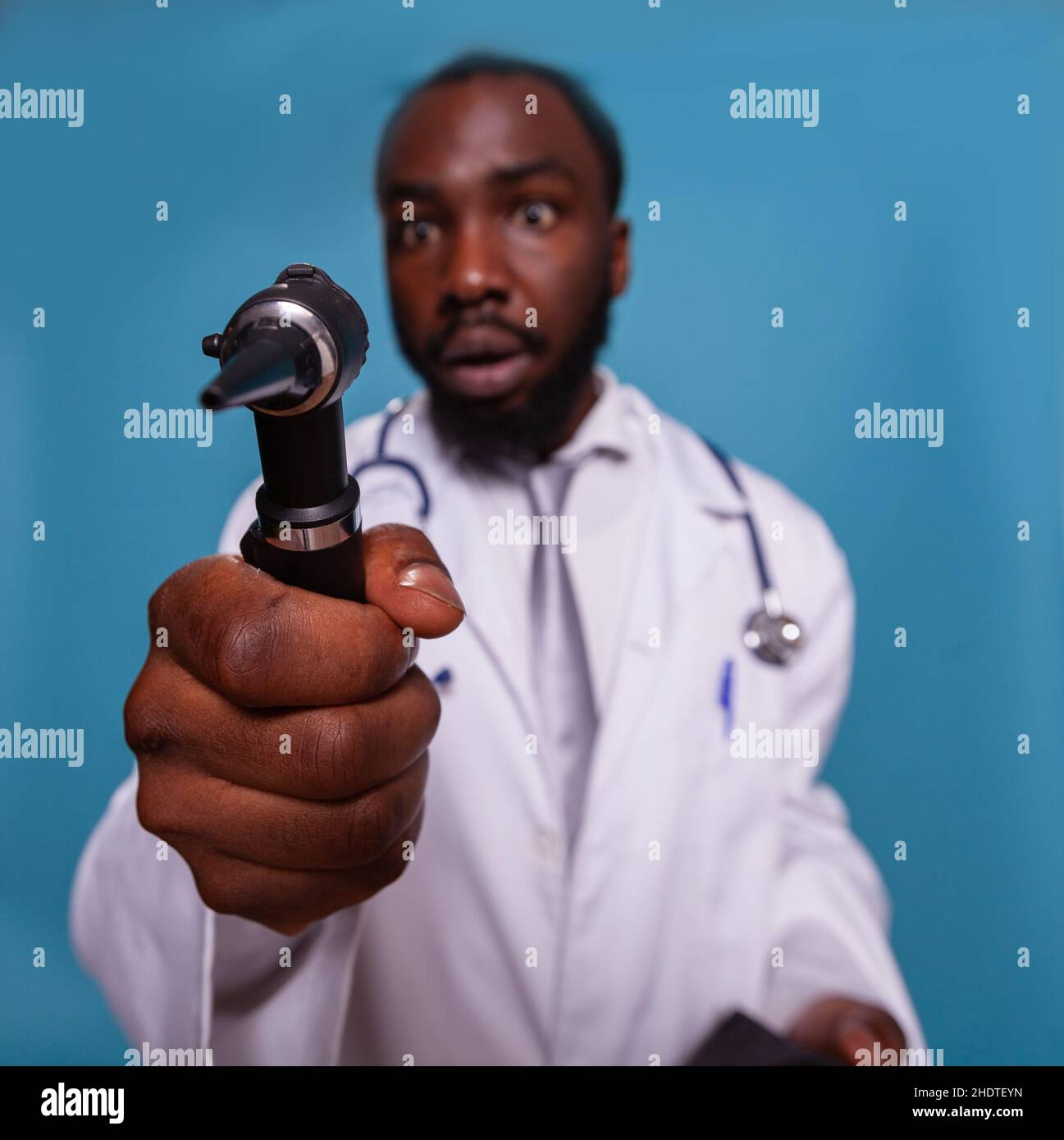 Closeup of otoscope in hand of african american doctor with funny face ...