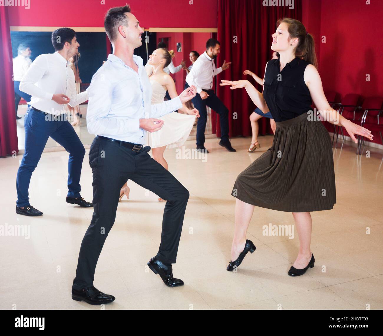 Dancing couples enjoying active dance Stock Photo - Alamy