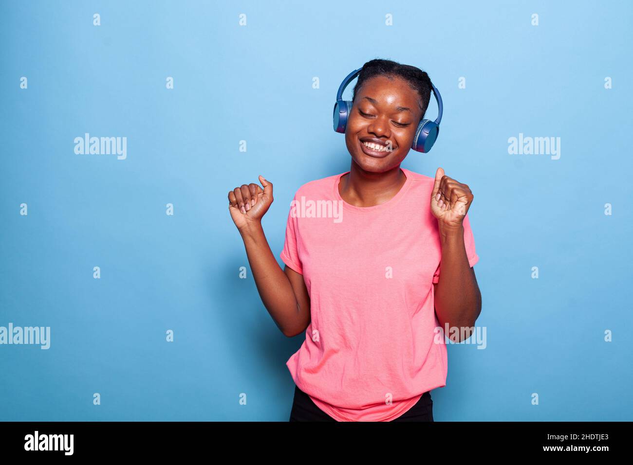 African american young student listening music using headset dancing ...