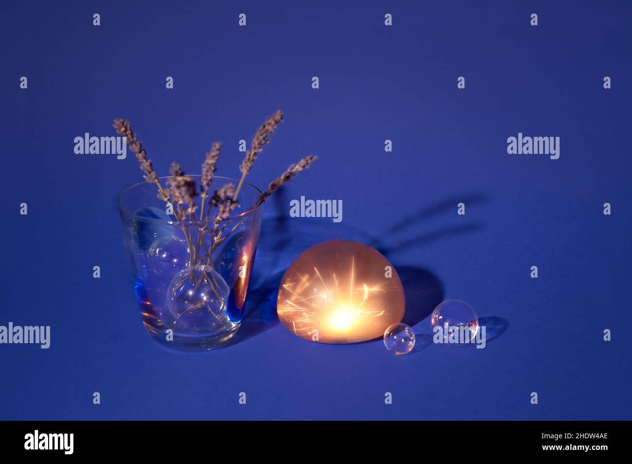 Dry lavender in glass, magic light with sparkles and orange glow. Dark ...