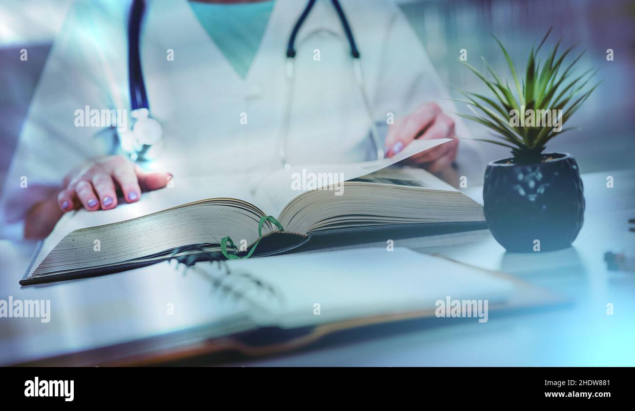 Female doctor reading a textbook in medical office; light effect Stock ...