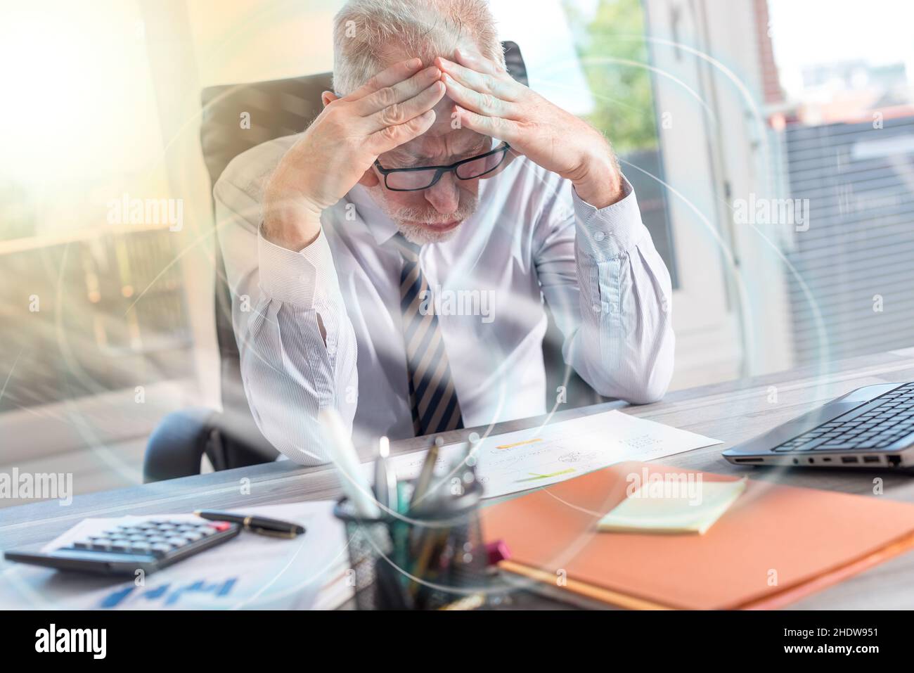 Portrait of concerned businessman sitting in office, light effect Stock ...
