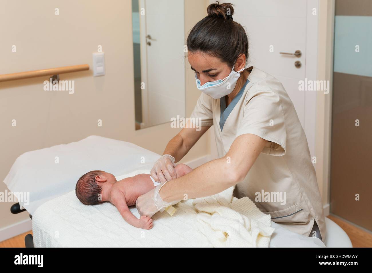 Female physical therapist wearing a face mask while working with a ...