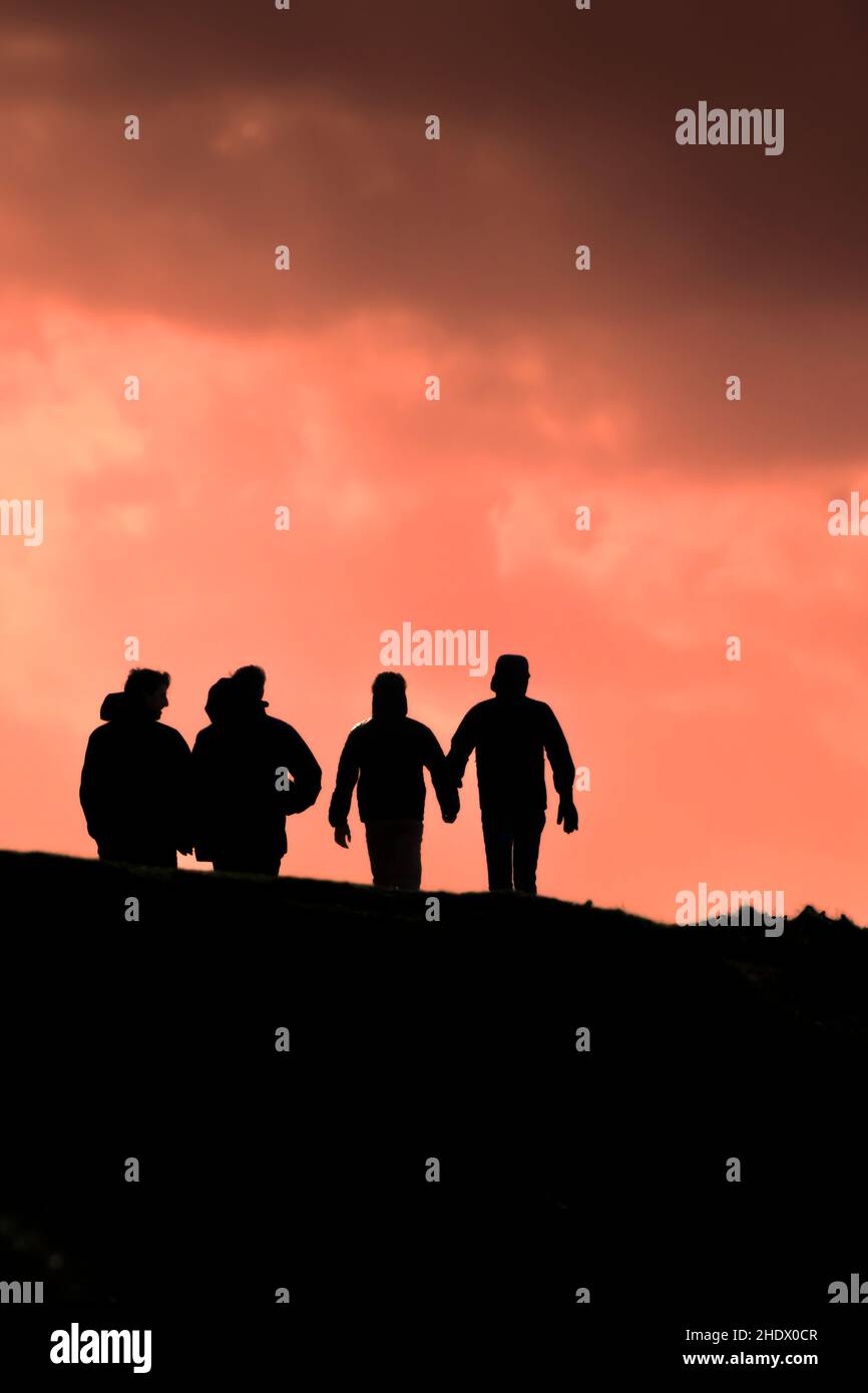 A group of walkers silhouetted by an intense sunset Stock Photo - Alamy