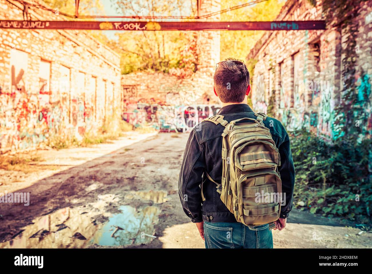 Back view of a teenager with a backpack in a rough urban area Stock ...