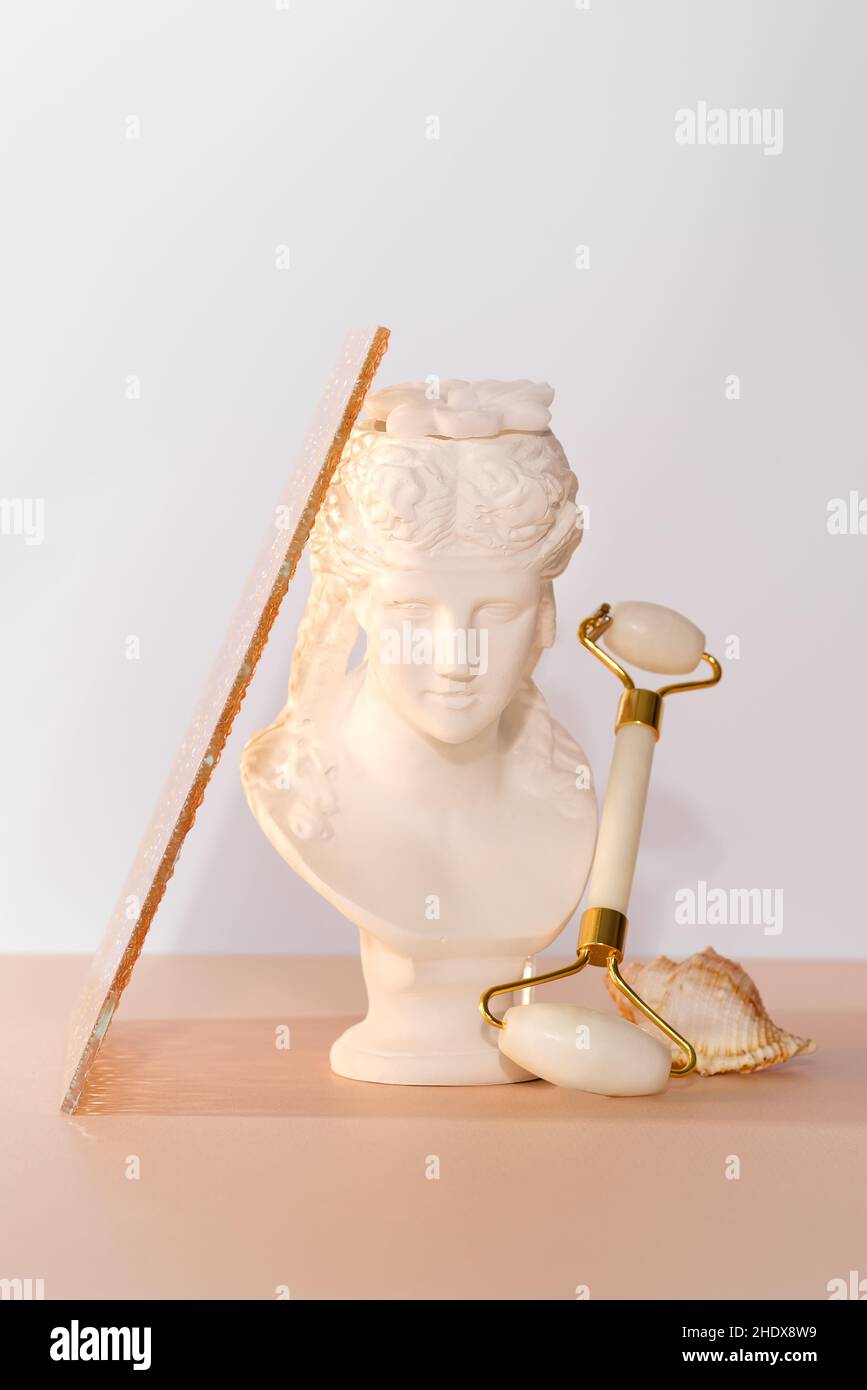 White marble head of a young woman with a face roller Stock Photo - Alamy