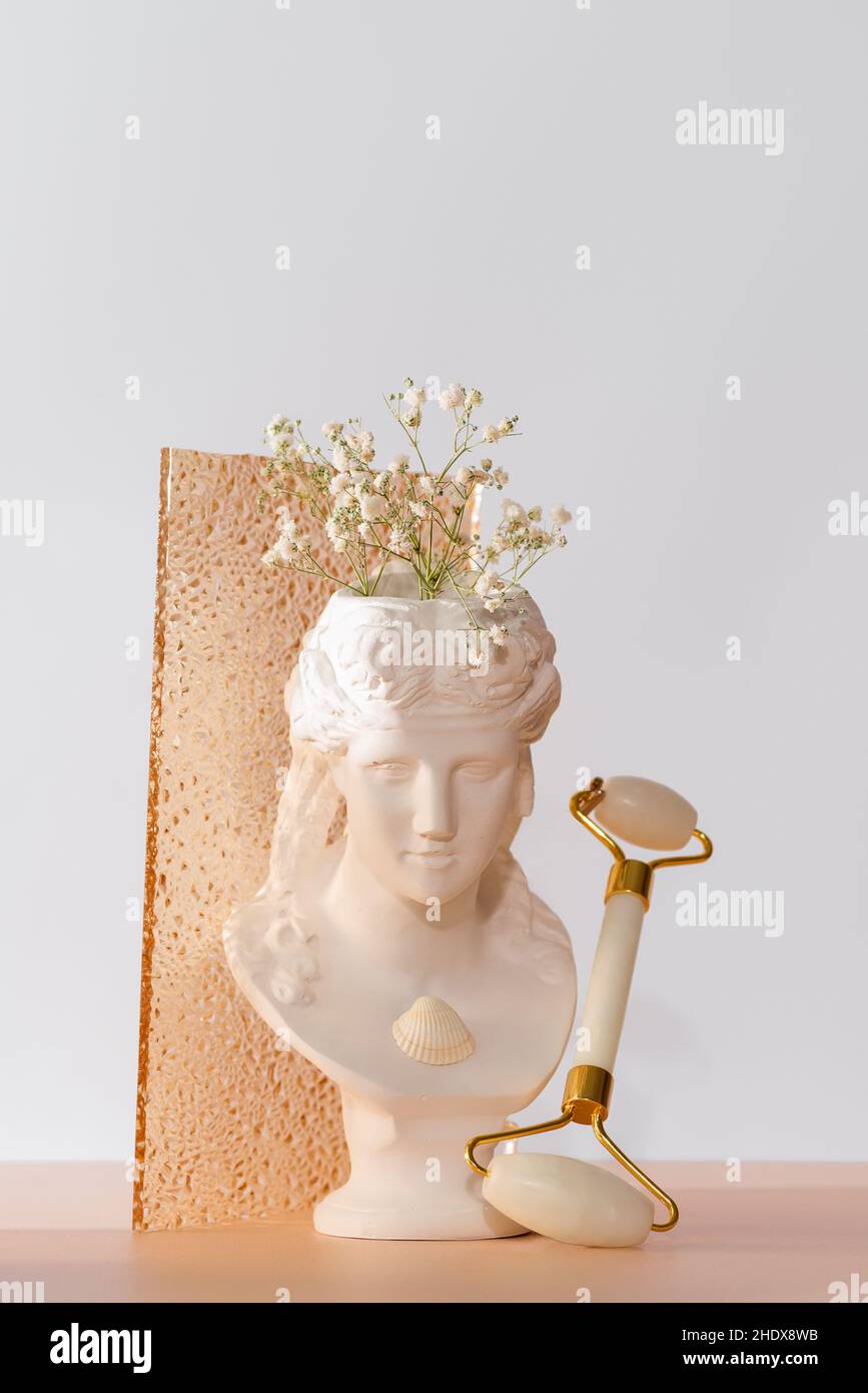 White marble head of a young woman with a face roller Stock Photo - Alamy