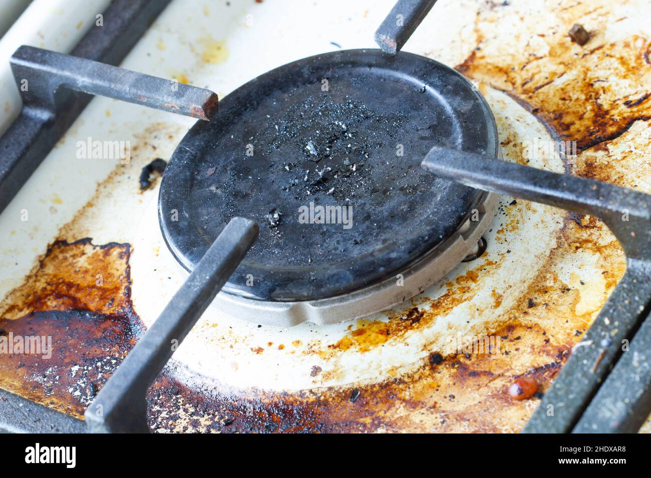 Dirty gas stove surface. Gas burner and cast iron grate of a gas oven ... Dirty gas stove surface. Gas burner and cast iron grate of a gas oven ...
