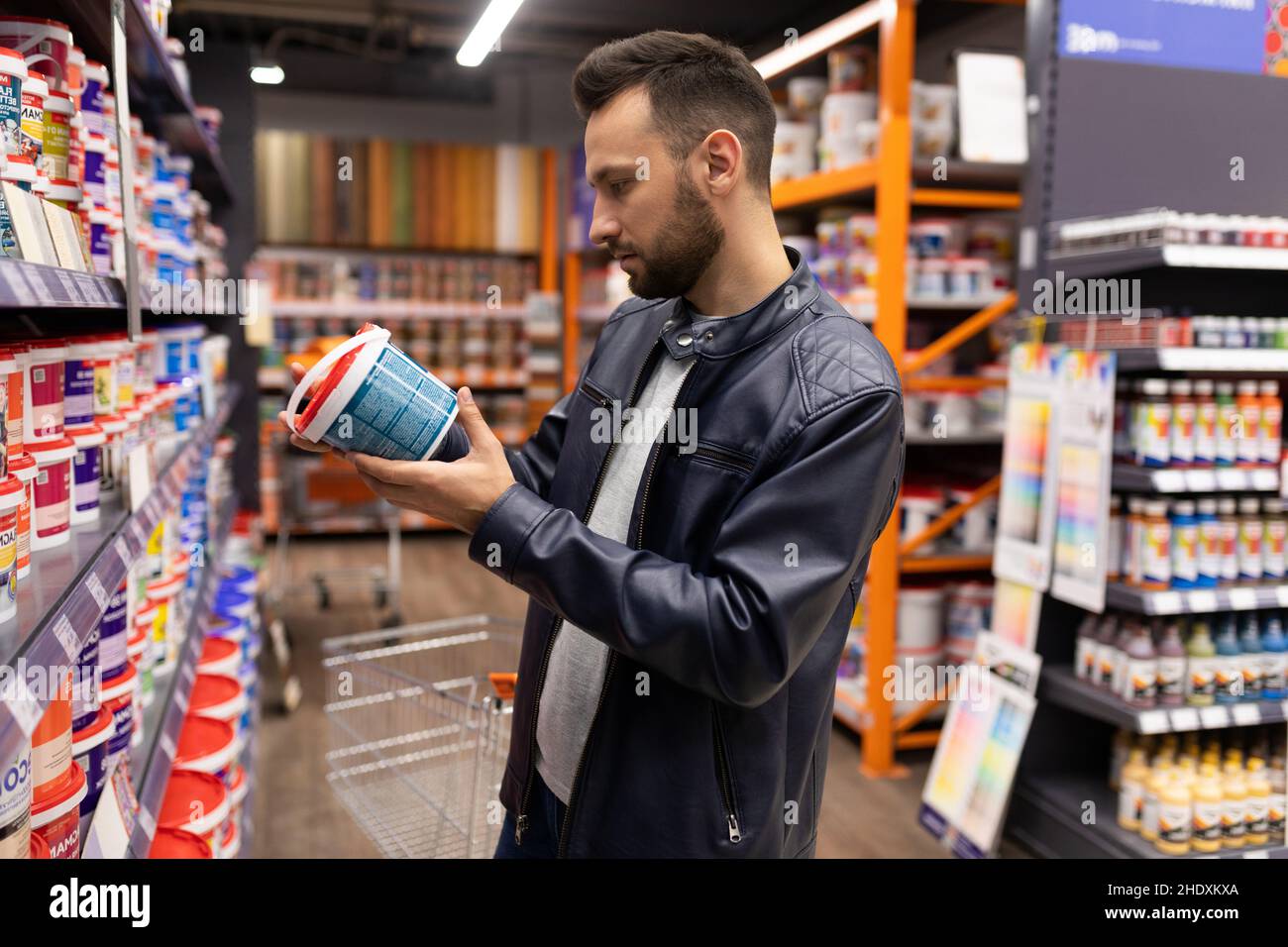 male buyer chooses paint in a hardware store, Concept of finishing ...