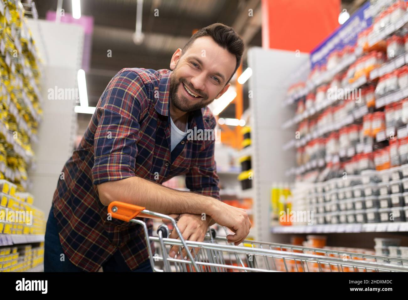 happy customer with a smile on his face next to a shopping basket in a ...